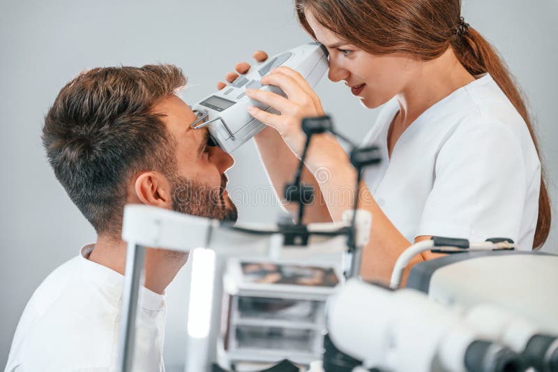 Modern Technologies. Man`s Vision Checked by Female Doctor in the ...