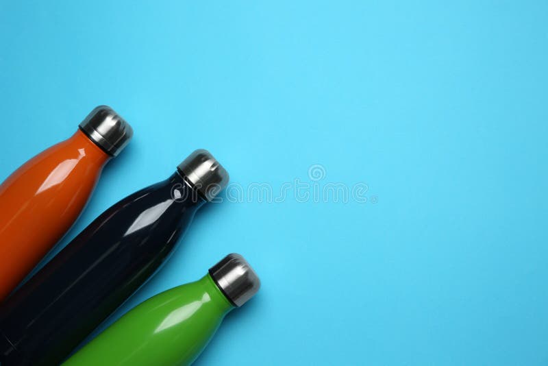 Modern Thermo Bottles on Light Blue Background, Flat Lay. Space for ...