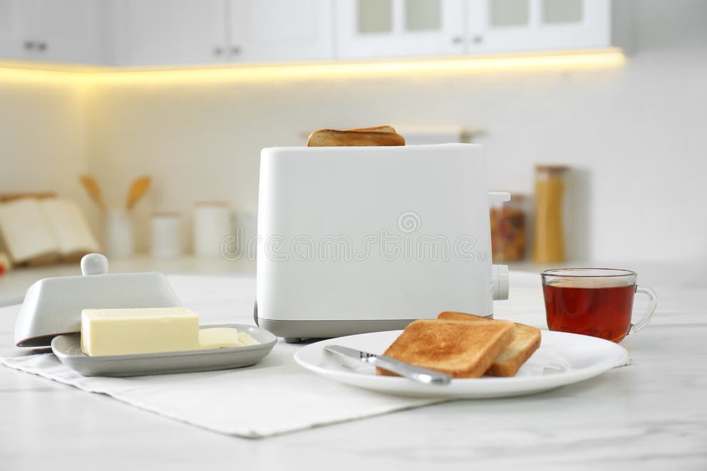 Modern Toaster with Bread Slices, Cup of Tea and Butter on White Marble ...