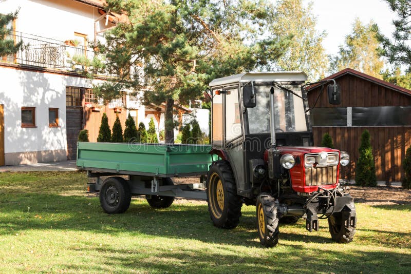 Modern Tractor with Empty Trailer on Green Lawn Outdoors Stock Photo ...
