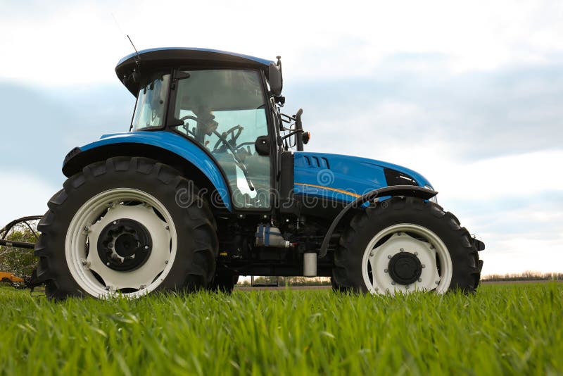 Modern Tractor in Field on Sunny Day. Agricultural Industry Stock Photo ...