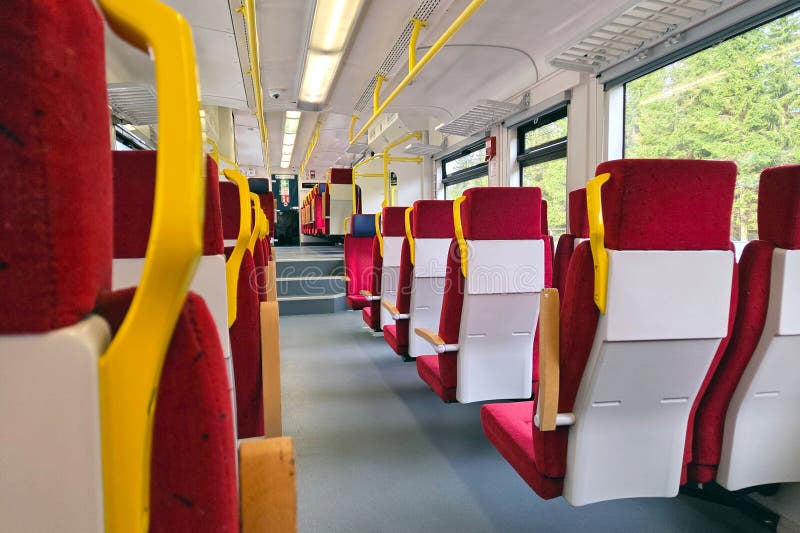 Modern Train Interior with Vibrant Red Seats and Yellow Handrails in ...