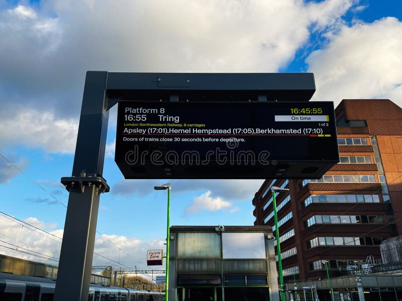 Modern Train Station Platform Sign Displaying Schedule Under a Cloudy ...