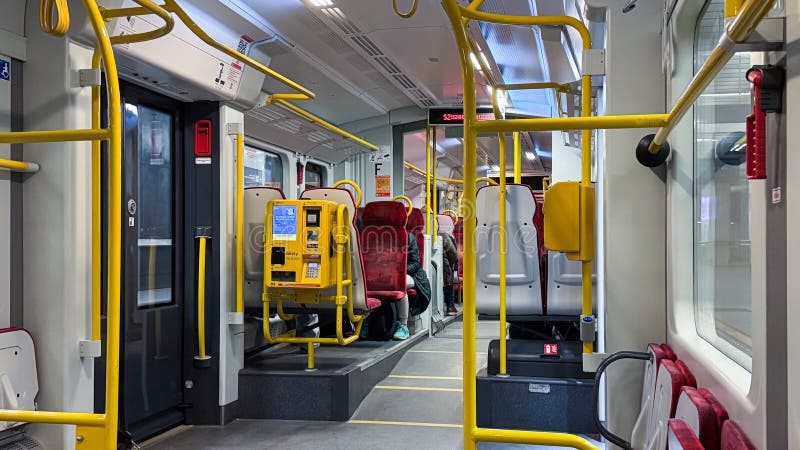 Modern Urban Train Interior with Yellow Handrails and Red Seating on a ...