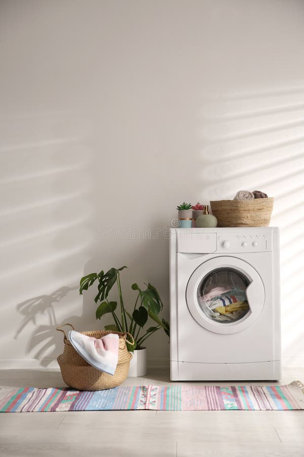Modern Washing Machine and Wicker Basket with Laundry Near Wall ...