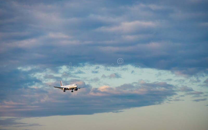 Modern White Airplane Flying in Cloudy Sky Stock Photo - Image of plane ...