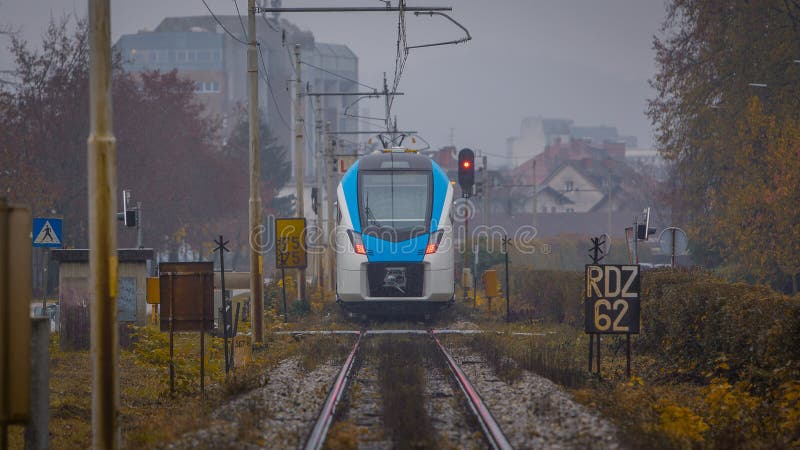 Modern White and Blue Passenger Commuter Train Passing by in Rain ...
