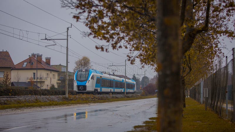 Modern White and Blue Passenger Commuter Train Passing by in Rain ...