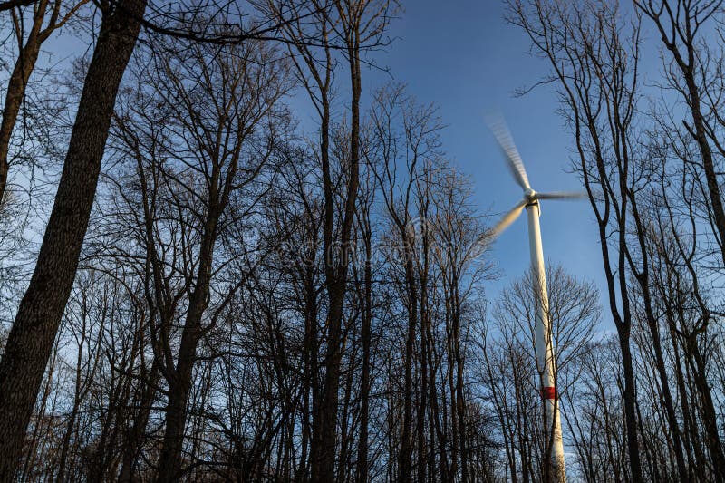 Modern Wind Turbine Spinning Behind Forest Trees Stock Image - Image of ...
