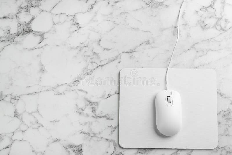 Modern Wired Optical Mouse and Pad on Marble Table, Top View. Space for ...