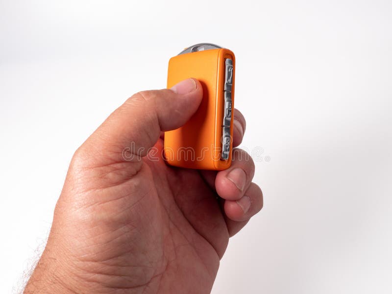 Modern Wireless Orange Ignition Key in Hand on a White Background ...