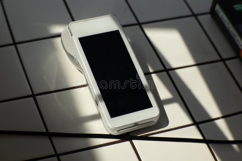 Modern Wireless Payment Terminal Placed on a Tiled Surface in Natural ...