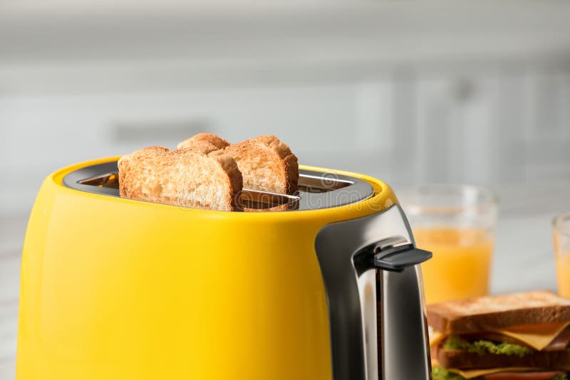 Modern Yellow Toaster with Roasted Bread Slices on Table, Closeup Stock ...