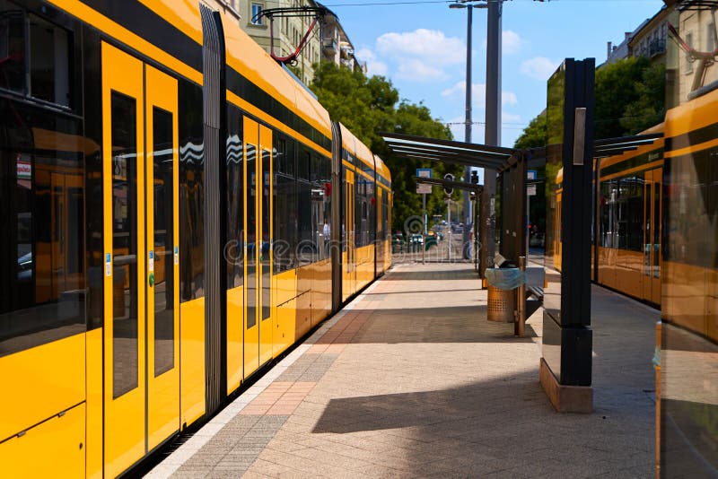 A Modern Yellow Trauma Bus with Tinted Windows at a Public Transport ...
