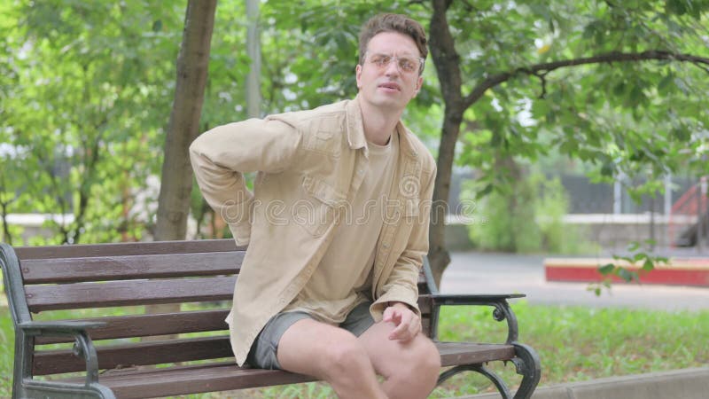 Modern Young Man with Back Pain Sitting on Bench Stock Footage - Video ...