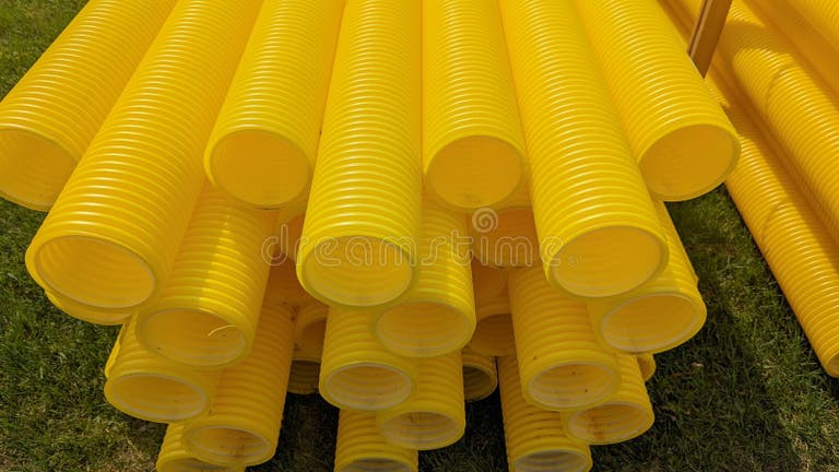 Bright Yellow Plastic Pipes Stacked Outdoors for Construction Use in ...