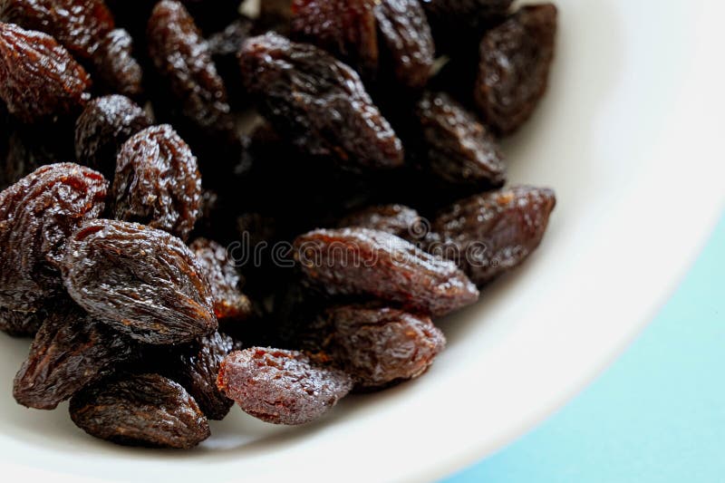 Moist Raisins in White Bowl on Blue Background Stock Image - Image of ...