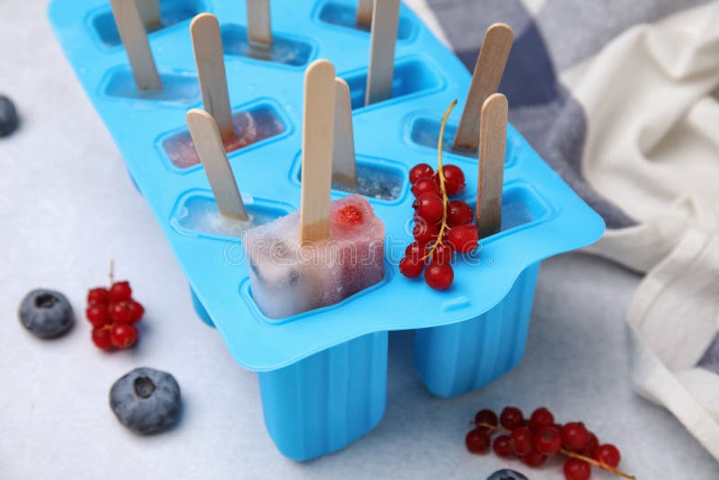 Mold with Fruit and Berry Ice Pops on Light Table, Closeup Stock Photo ...