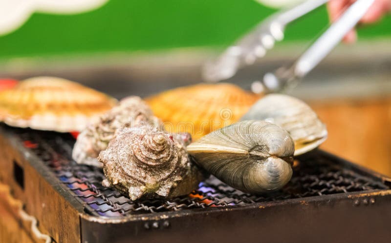 Mollusks are Cooked in a Cafe on Fire, Tokyo, Japan. Close-up. Stock ...