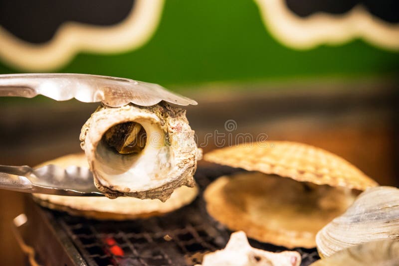 Mollusks are Cooked in a Cafe on Fire, Tokyo, Japan. Close-up. Stock ...