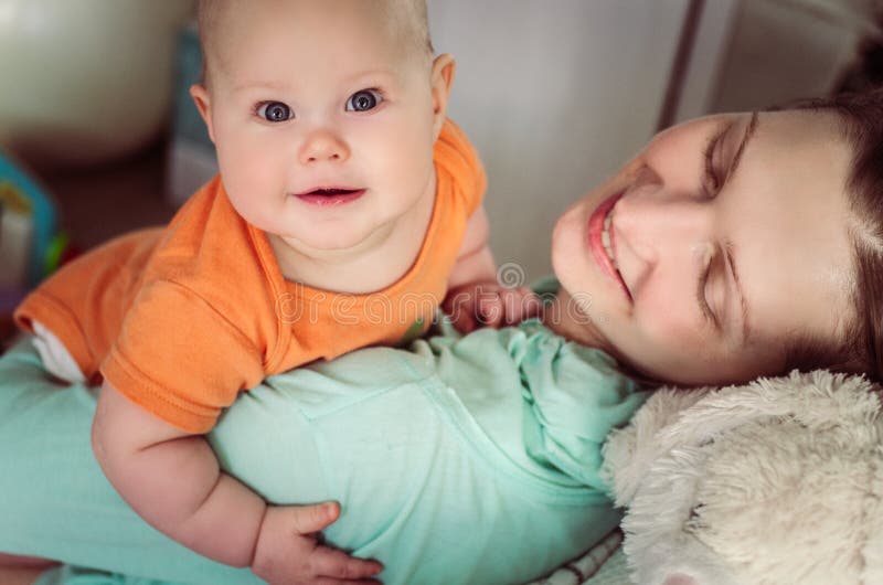 Mom and Baby are Resting and Smiling while Sitting on the Couch Stock ...