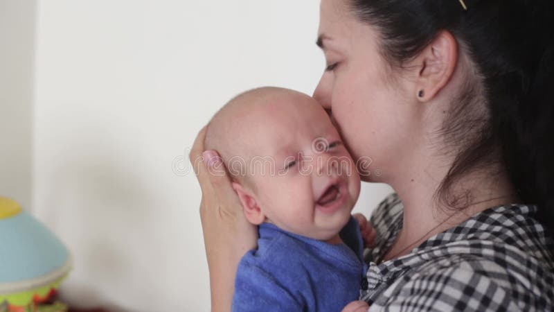 Mom comforts a crying baby stock footage. Video of kissing - 131620480
