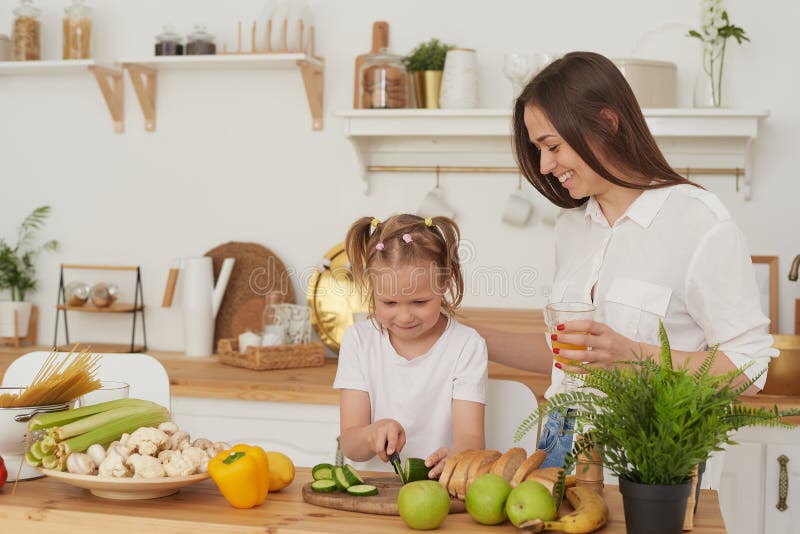 Mom Controls Her Daughter S Cutting Vegetables. Cooking Training Stock ...