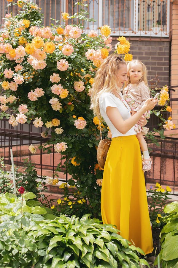 Mom and Daughter Admire the Yellow Rose Bushes, Take Selfies, Take ... Mom and Daughter Admire the Yellow Rose Bushes, Take Selfies, Take ...