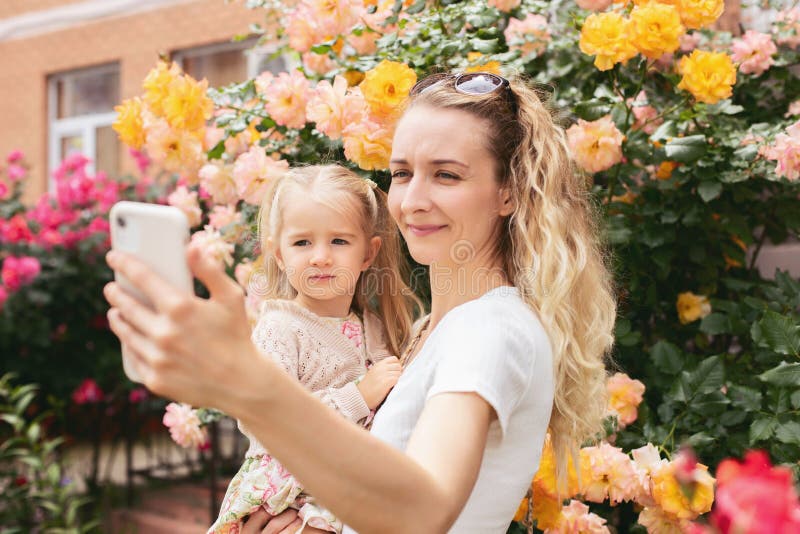 Mom and Daughter Admire the Yellow Rose Bushes, Take Selfies, Take ... Mom and Daughter Admire the Yellow Rose Bushes, Take Selfies, Take ...