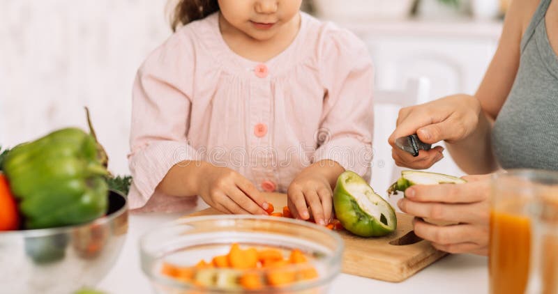 Mom and Daughter Cut Vegetables Together at the Table Stock Photo ...