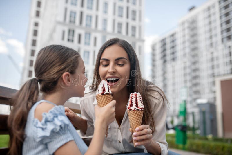 Mom And Daughter Eating Ice Cream And Looking Pleased Stock Image