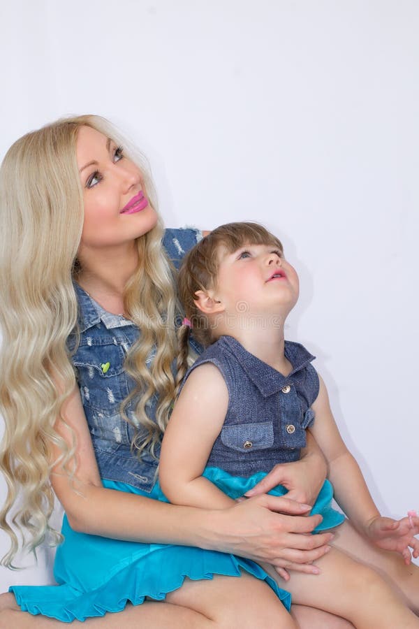 Mom And Daughter In Identical Dresses Are Sitting On The Stairs