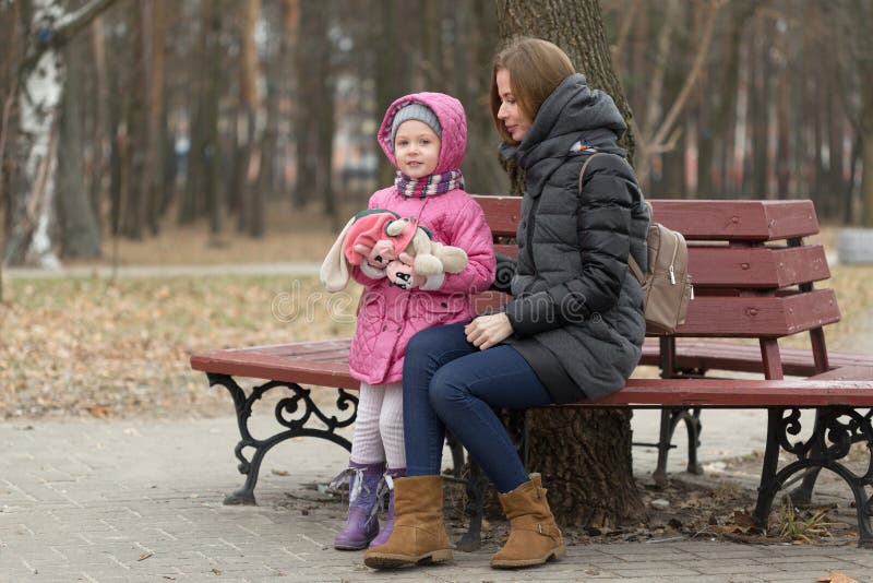 Mom And Daughter Are Sitting On A Park Bench Stock Image Image Of