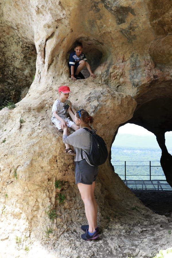 Mom Helps Her Son Descend from Cliff in Grotto on Una-Koz Ridge Stock ... Mom Helps Her Son Descend from Cliff in Grotto on Una-Koz Ridge Stock ...