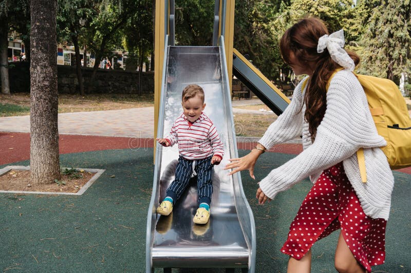 Mom and Son are Playing on the Playground. Mom Supports Her Son. Stock ...