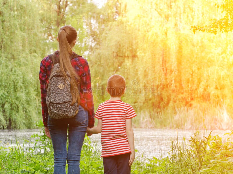 Mom and Son Stand Against the Background of the Lake and the Forest ...