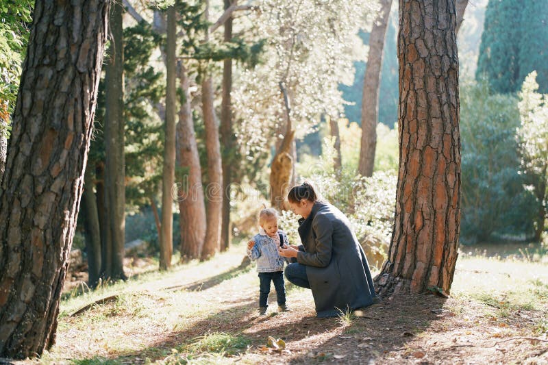 Dad Squatted in Front of the Little Girl Holding Her Hands on a Rocky ... Dad Squatted in Front of the Little Girl Holding Her Hands on a Rocky ...