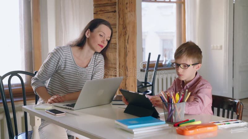 Mom Working on Laptop and Helping Son Study on Tablet Spbas. Tech ...