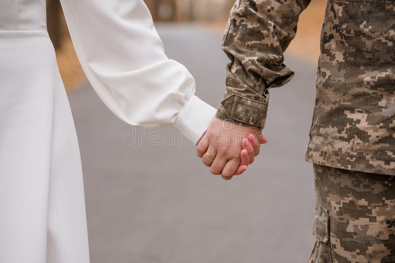 A Moment of Unity: a Bride and Soldier Holding Hands Together Stock ...