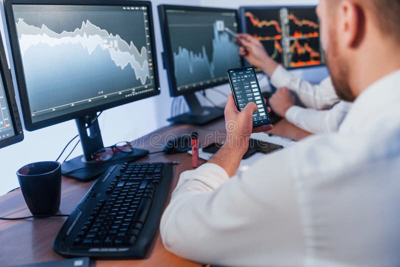 Money Investment. Two Stock Traders Working in the Office with Exchange ...