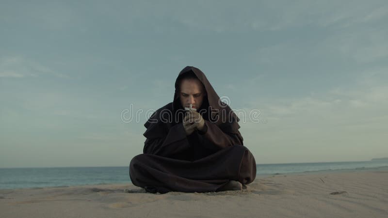 Monk Collected in Prayer Sitting on the Beach in the Evening Stock ...