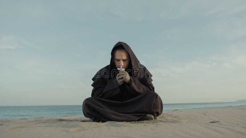 Monk Collected in Prayer Sitting on the Beach in the Evening Stock ...