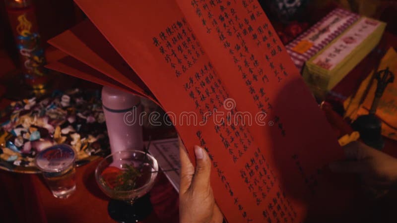 A Monk Reading and Holding a Red Praying Paper with Chinese Text in ...