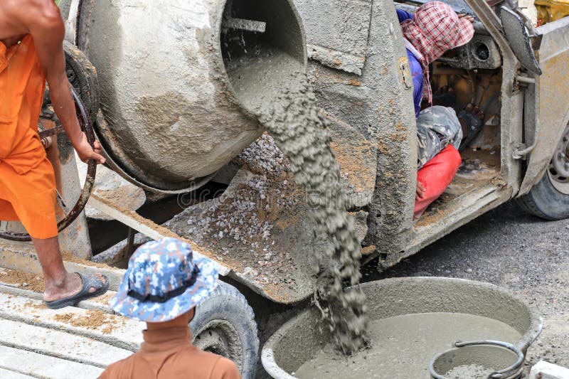 A Monk and a Worker are Pouring Ready-mixed Concrete into a Cement ...