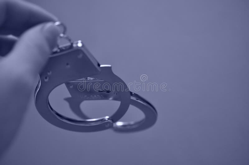 Monochrome Blue Background - Handcuffs in Hand Stock Image - Image of ...