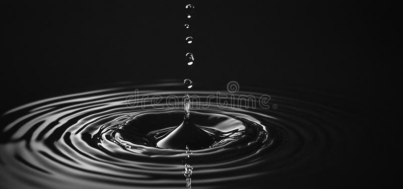 Monochrome Water Droplet Impacting a Dark Surface Creating Ripple ...