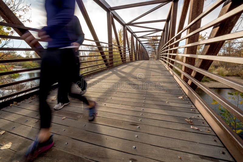 Monring Run Across a Foot Bridge with Autumn Trees Stock Image - Image ...
