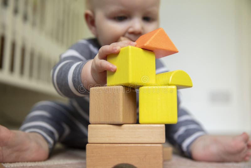 A 7 Month Old Baby Pushing Over a Stack of Wooden Play Blocks Stock ...