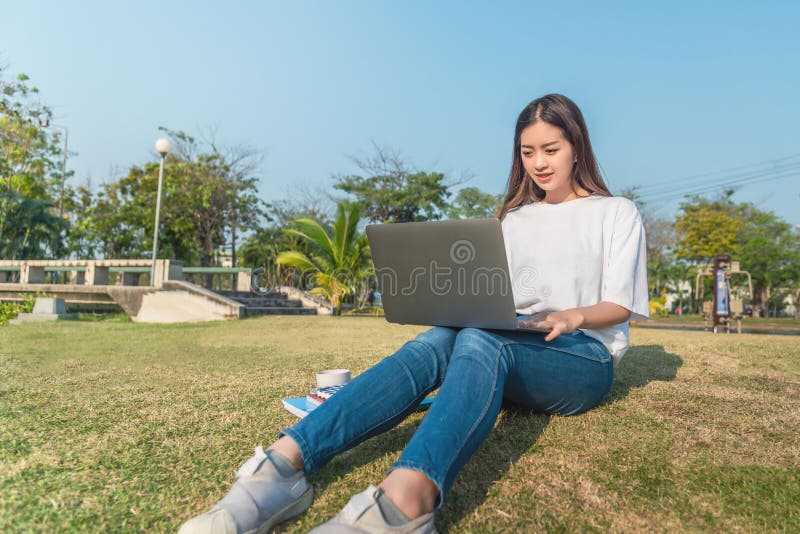 Mooie Jonge Glimlachende Vrouw Die Tablet in Openbaar Park Gebruiken ... Mooie Jonge Glimlachende Vrouw Die Tablet in Openbaar Park Gebruiken ...