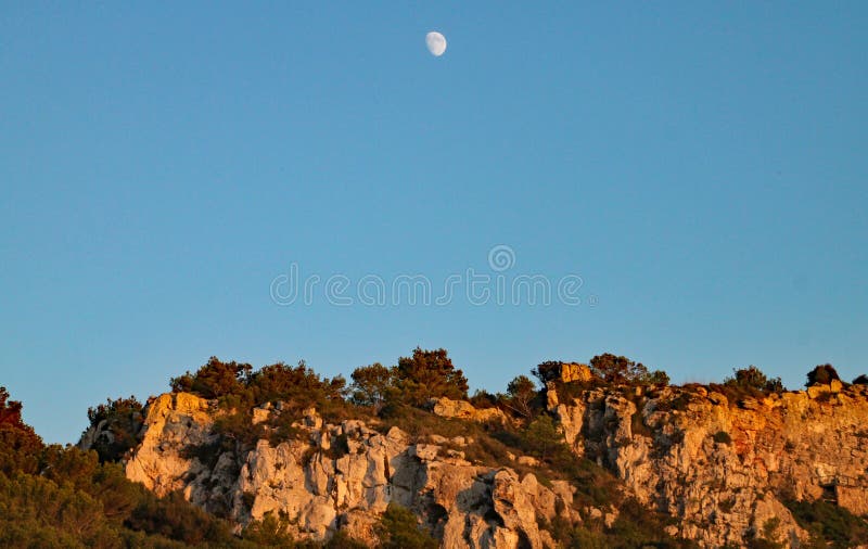 The Moon is Above Red Coloured Cliffs in the Evening Sky Stock Photo ...